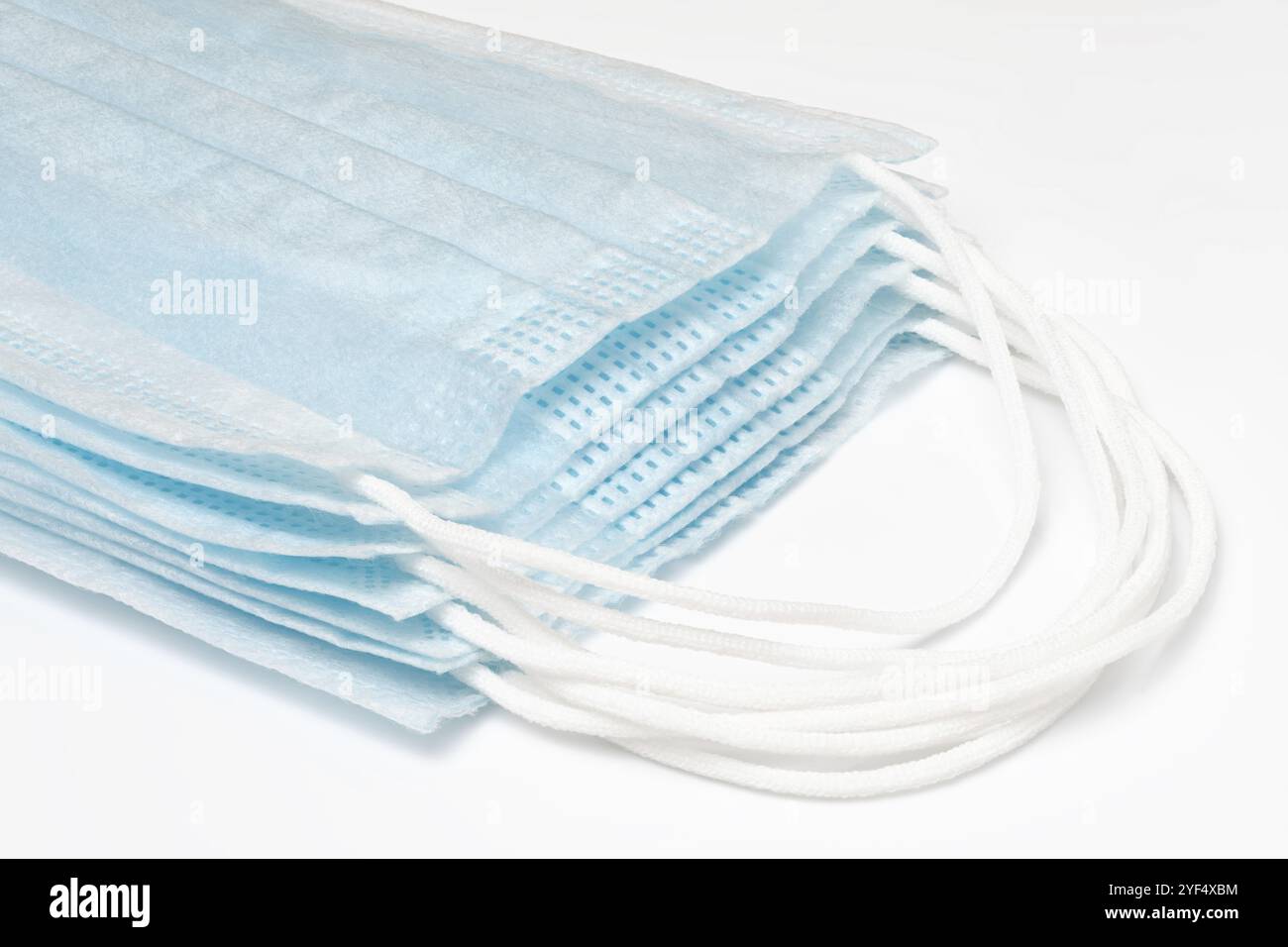 Close-up lot of medical surgical face masks with rubber ear straps on ...