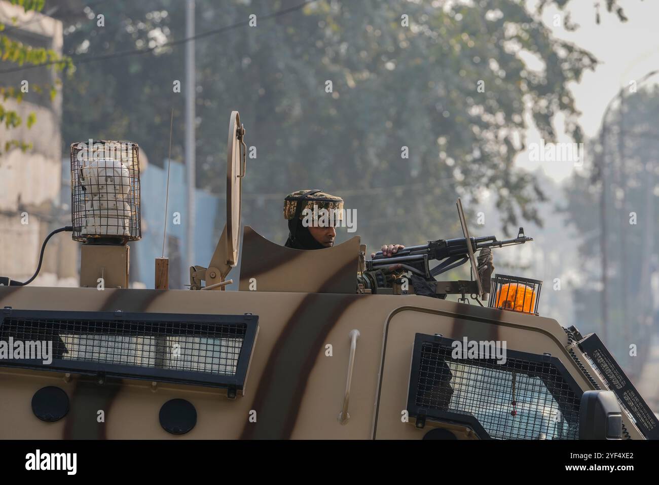 An Indian paramilitary soldier guards on top of his armored vehicle at ...