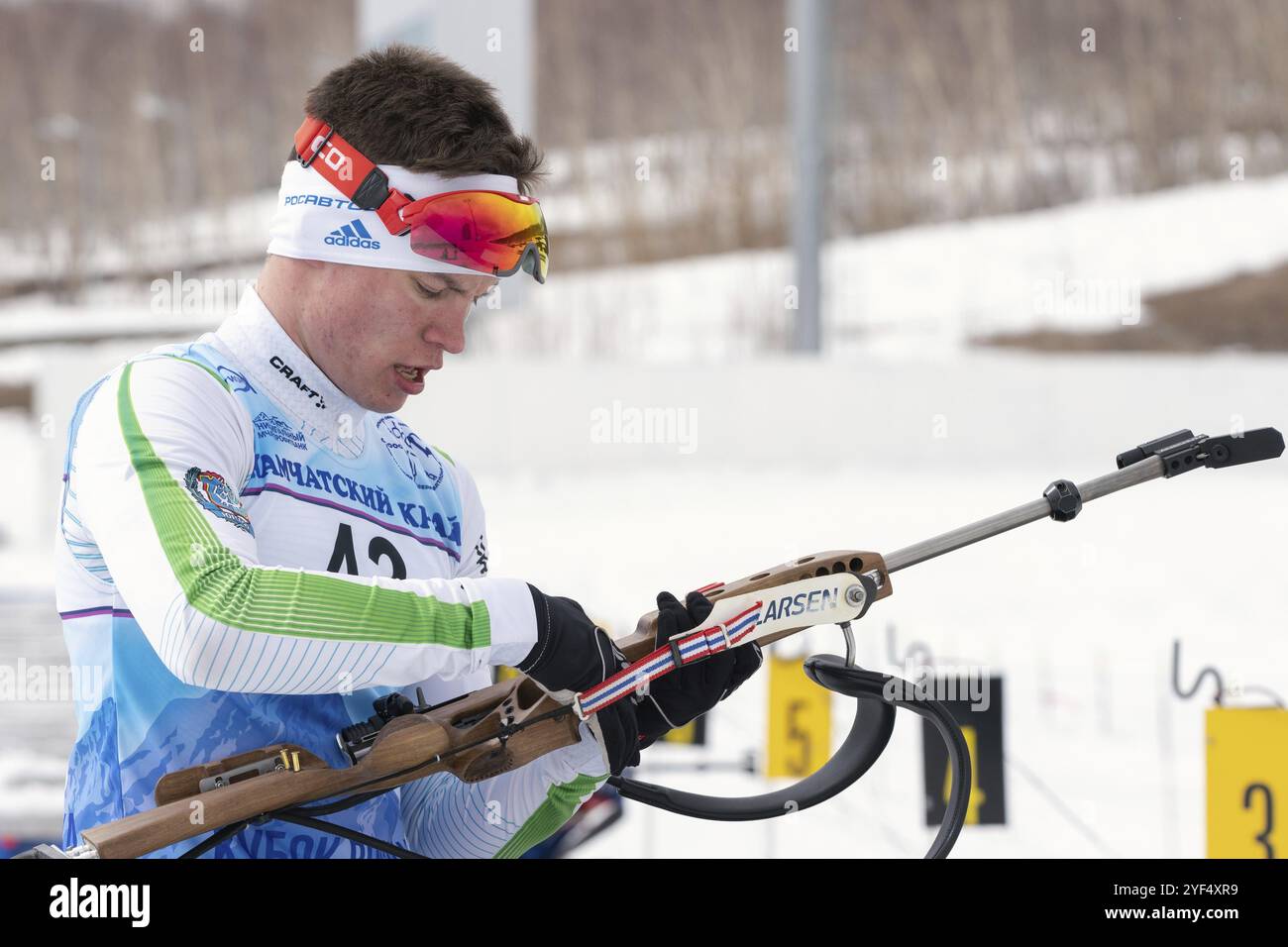 Biathlete reloads rifle before rifle shooting on shooting range ...