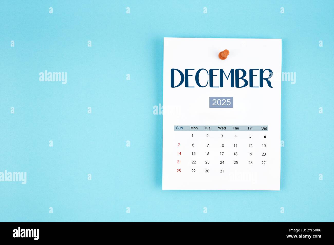 December 2025 calendar page with push pin on blue color background ...