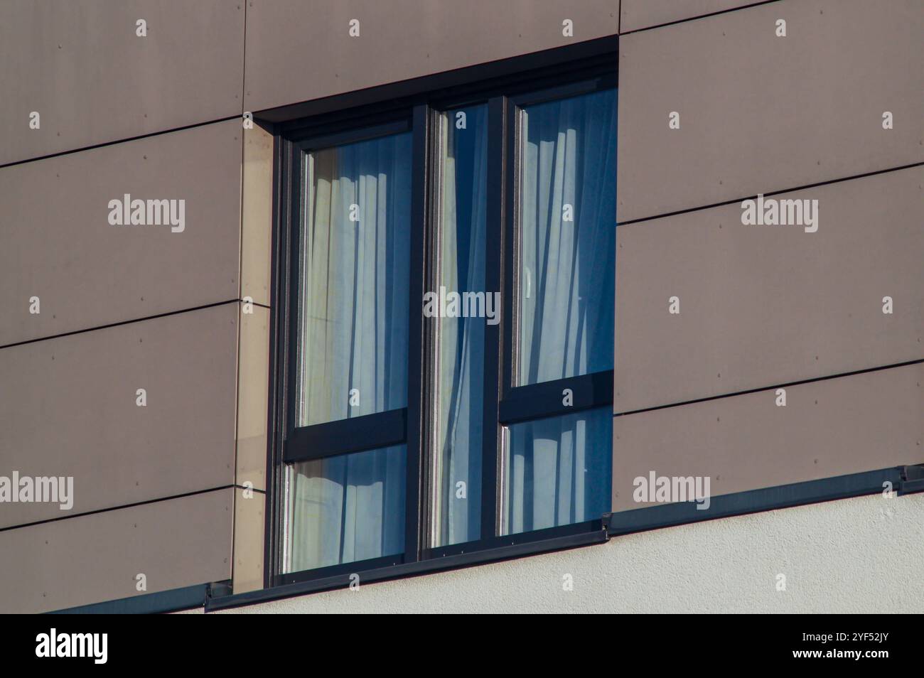 Sunlight illuminating curtains behind a window of a modern residential ...