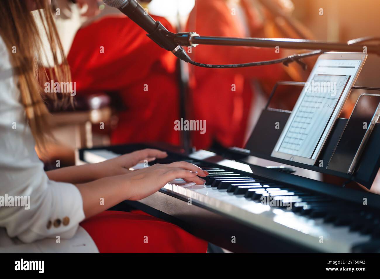 pianist playing on piano at dark stage closeup, woman plays at ...
