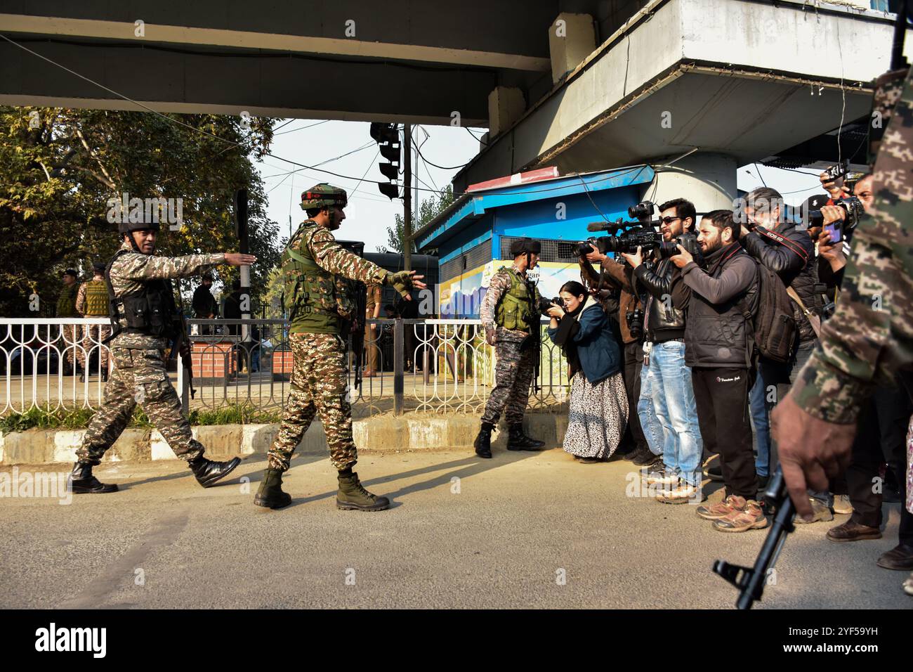 Paramilitary troopers stop journalists after a grenade attack at a Sunday market in Srinagar ...
