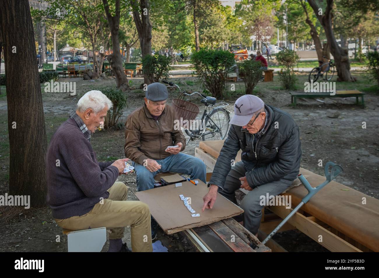 Retired older Men Playing Dominoes On Desk in the park. Old friends ...