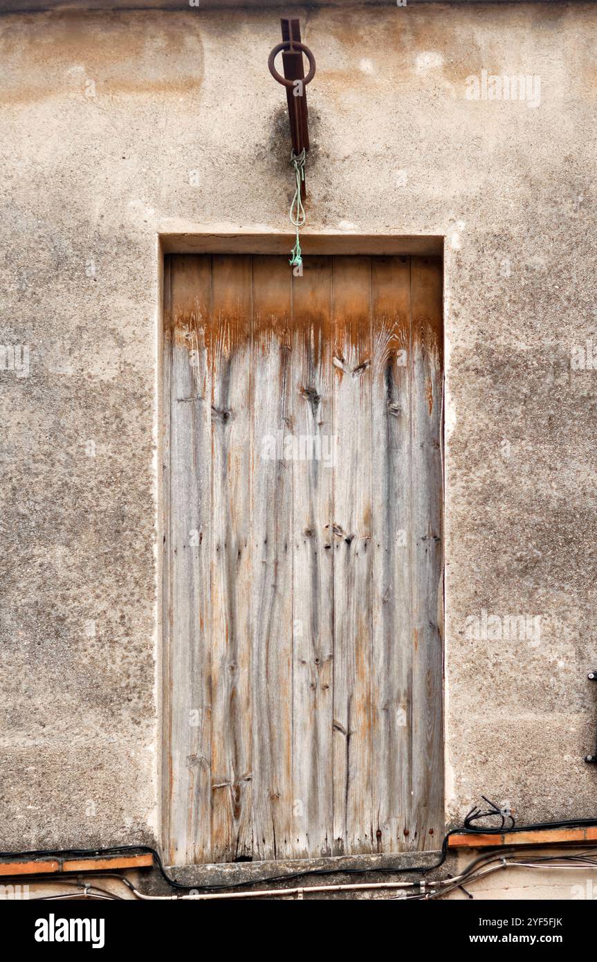 Rustic wooden door with visible wear and tear, framed by a concrete ...