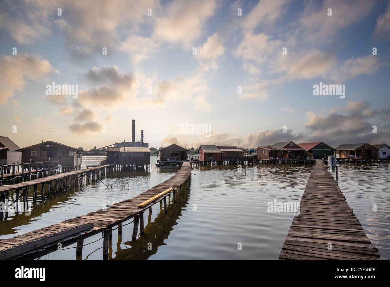 Wooden houses in the water at sunset. Long wooden walkways of the ...