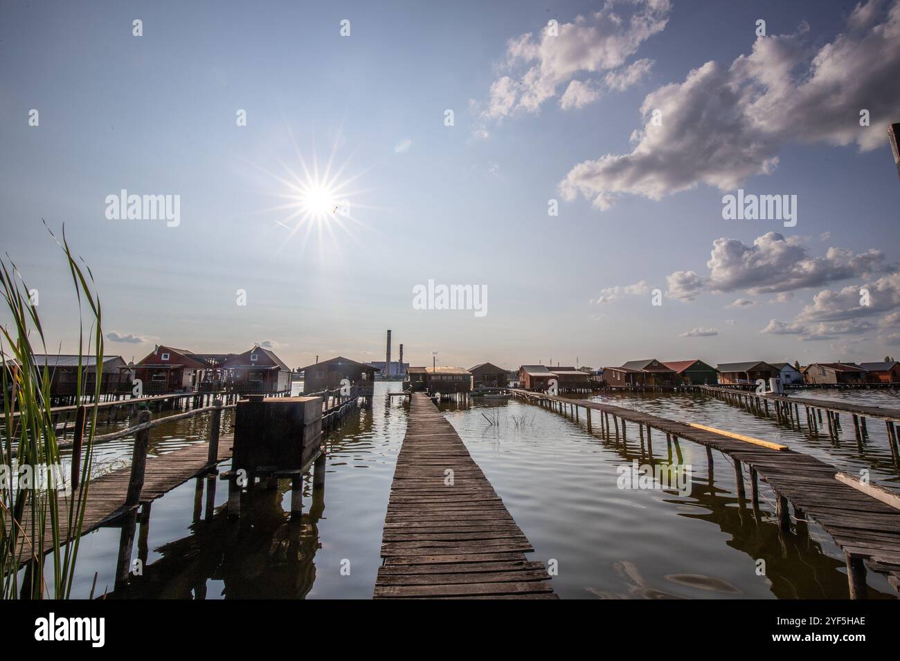 Wooden houses in the water at sunset. Long wooden walkways of the ...