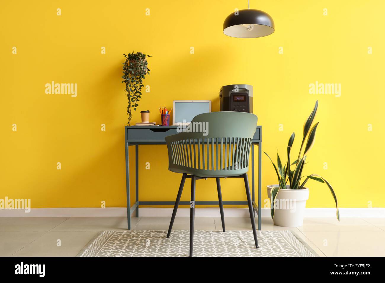 Interior of office with workplace, portable power station and plants ...