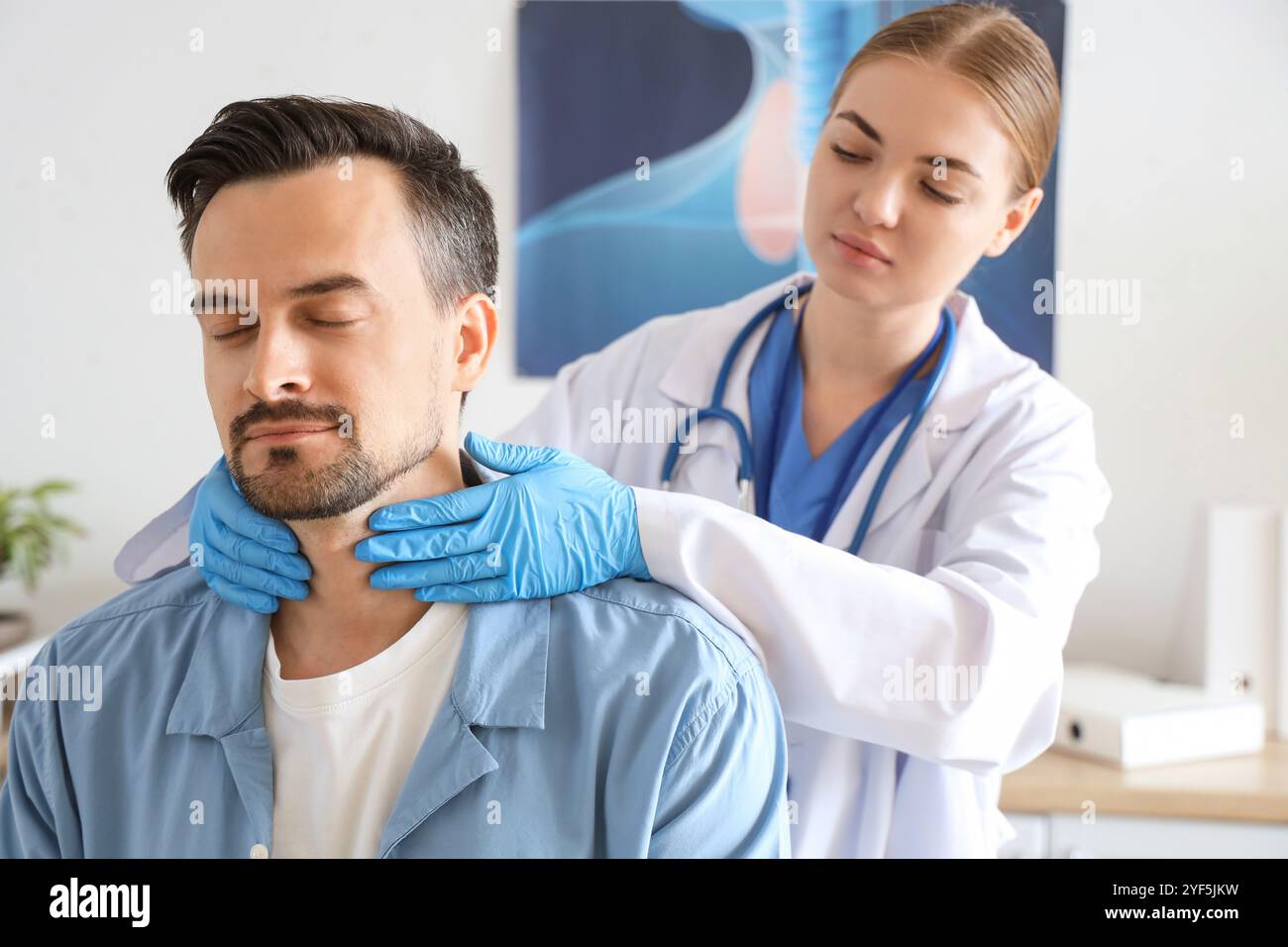 Female endocrinologist examining man's thyroid gland in clinic Stock ...