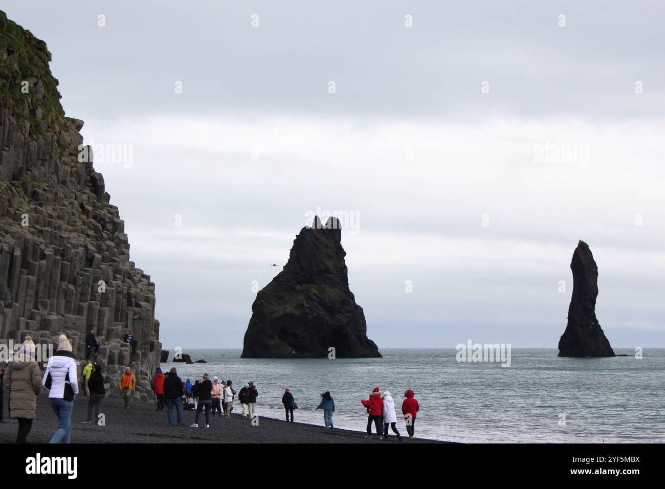 A photograph of tourists visiting Iceland’s Reynisfjara Beach on an ...