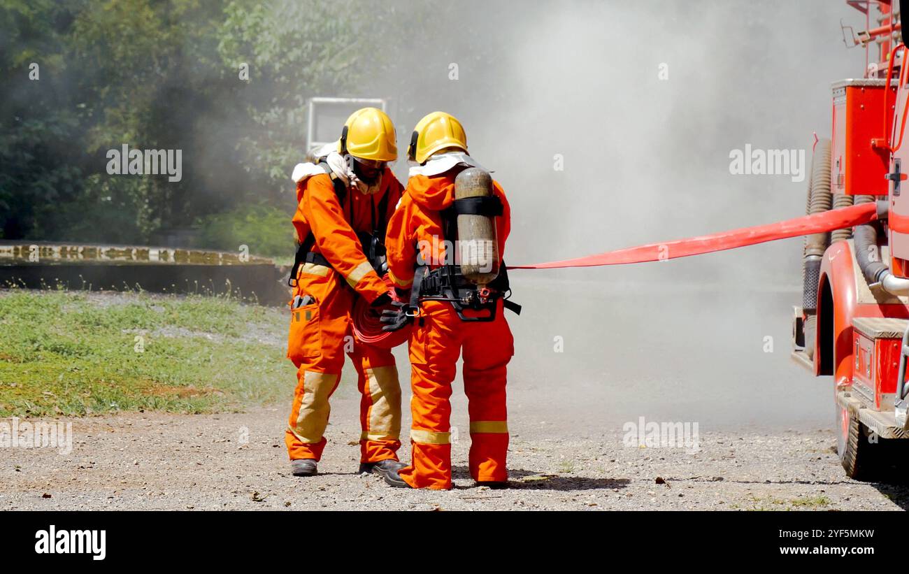 Firefighter fighting with flame using fire hose chemical water foam ...