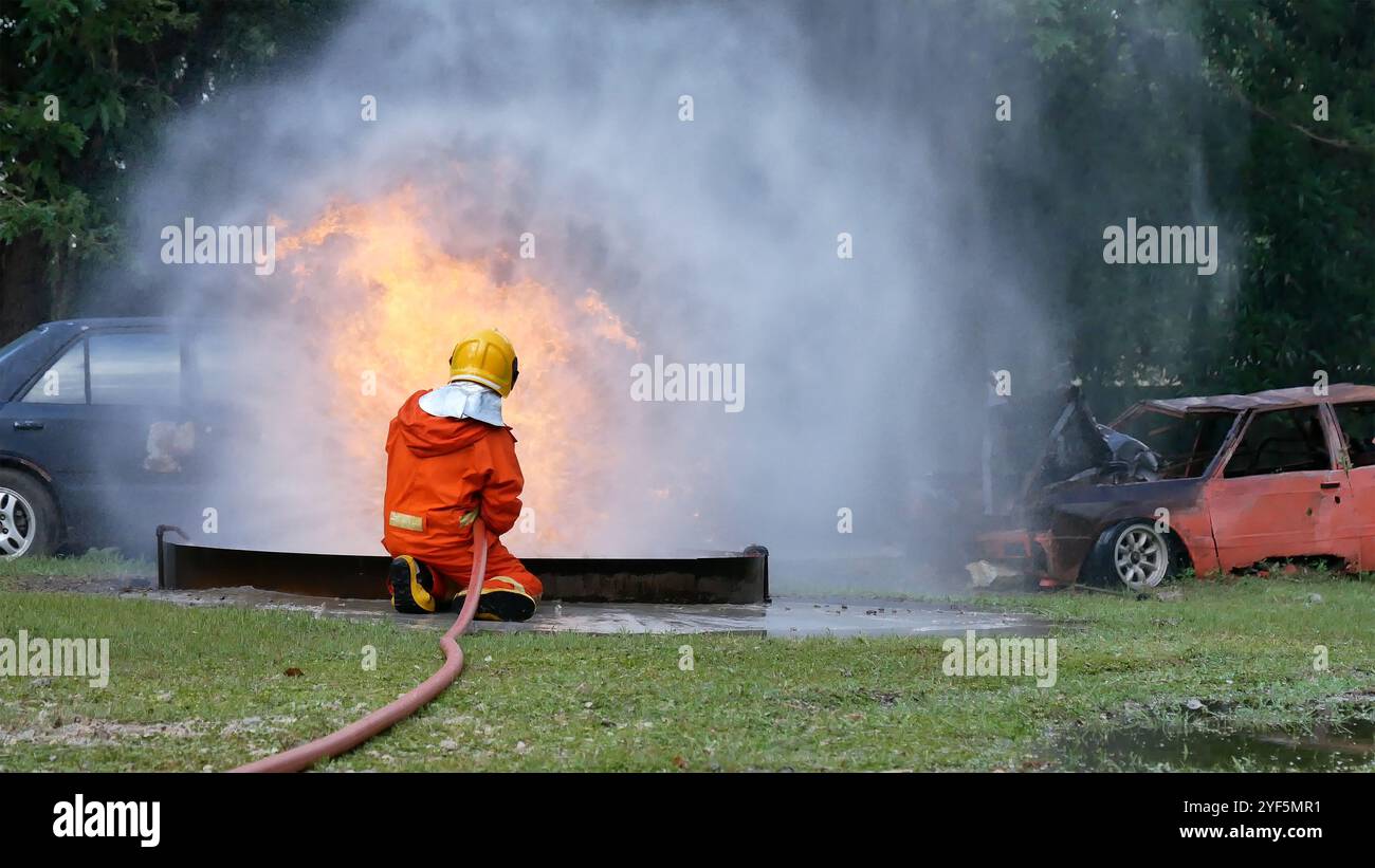 Firefighter fighting with flame using fire hose chemical water foam ...