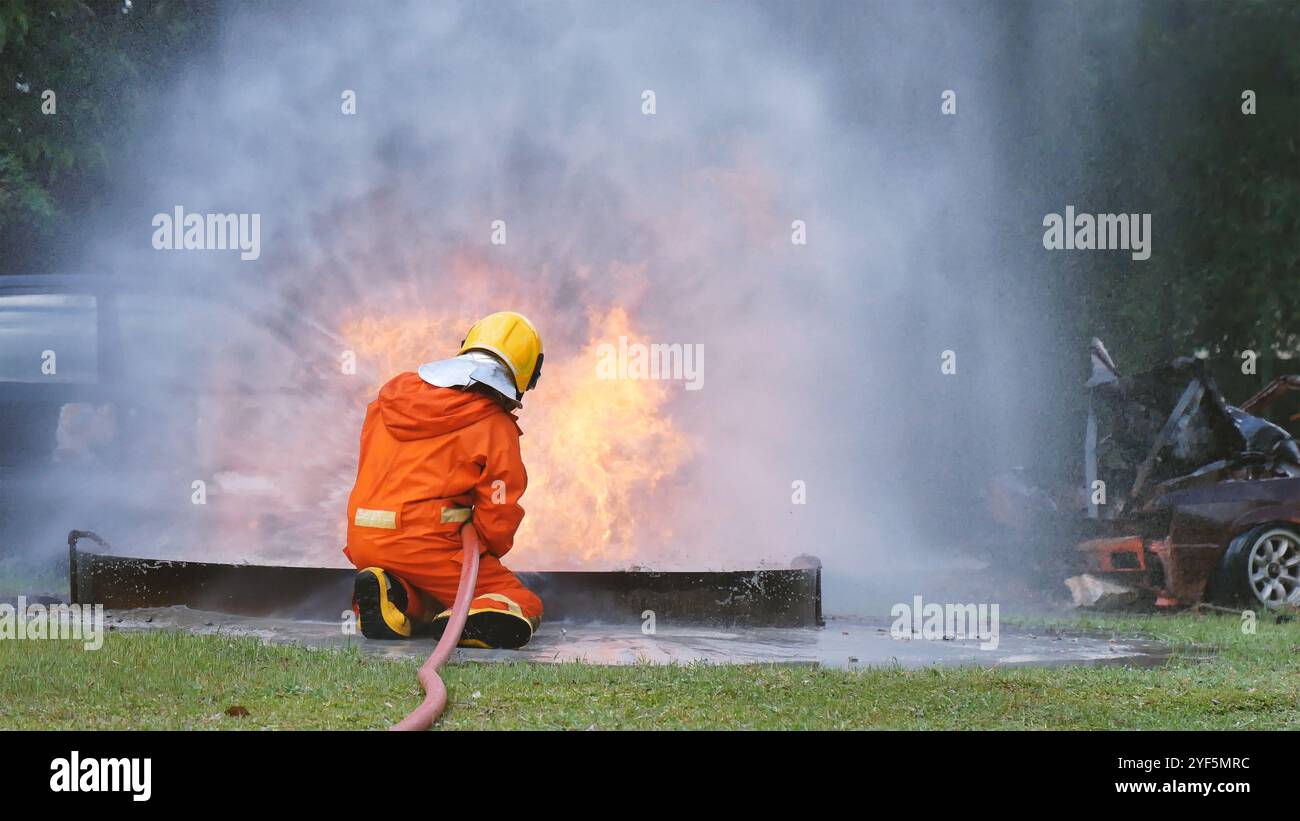 Firefighter fighting with flame using fire hose chemical water foam ...