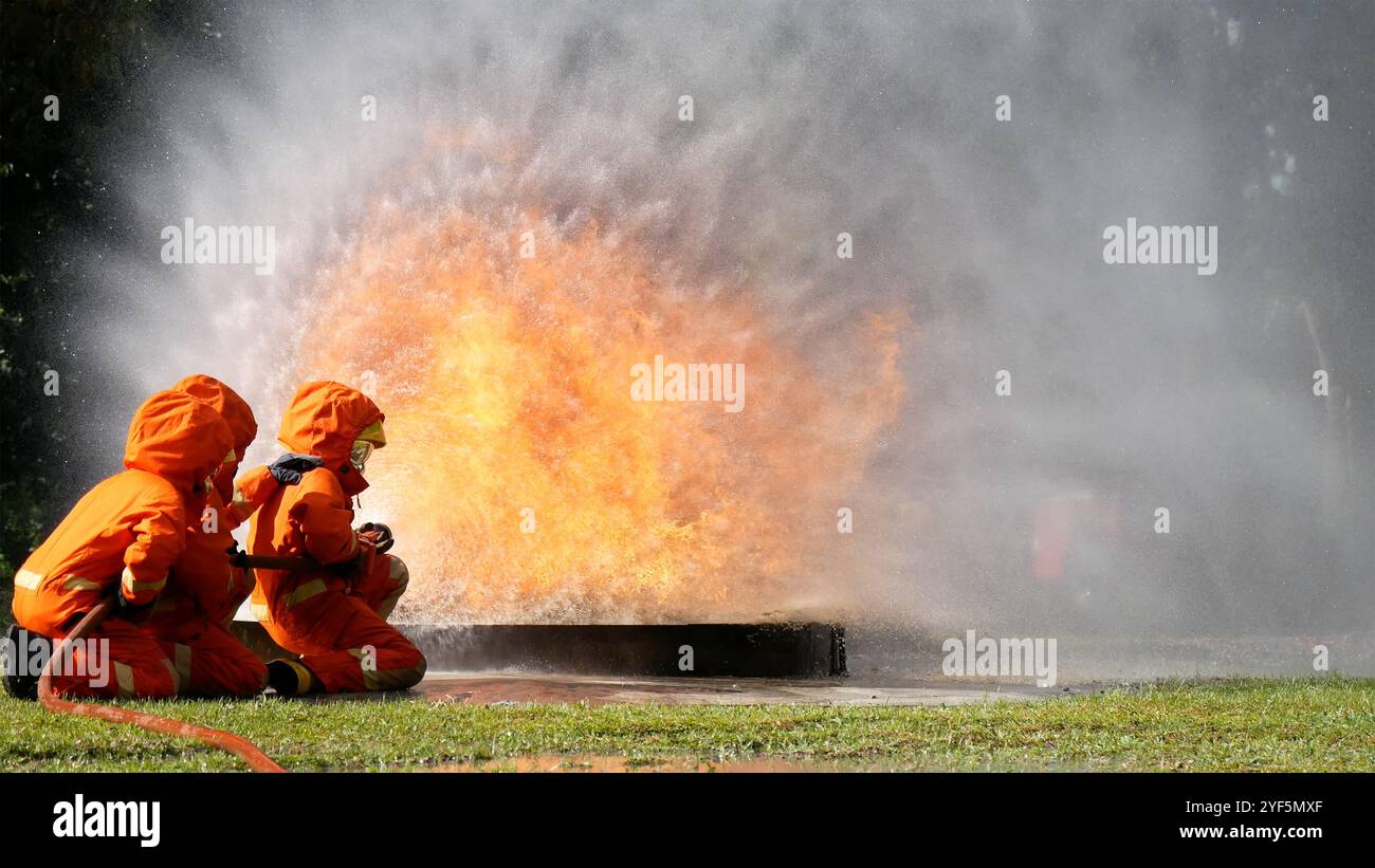 Firefighter fighting with flame using fire hose chemical water foam ...
