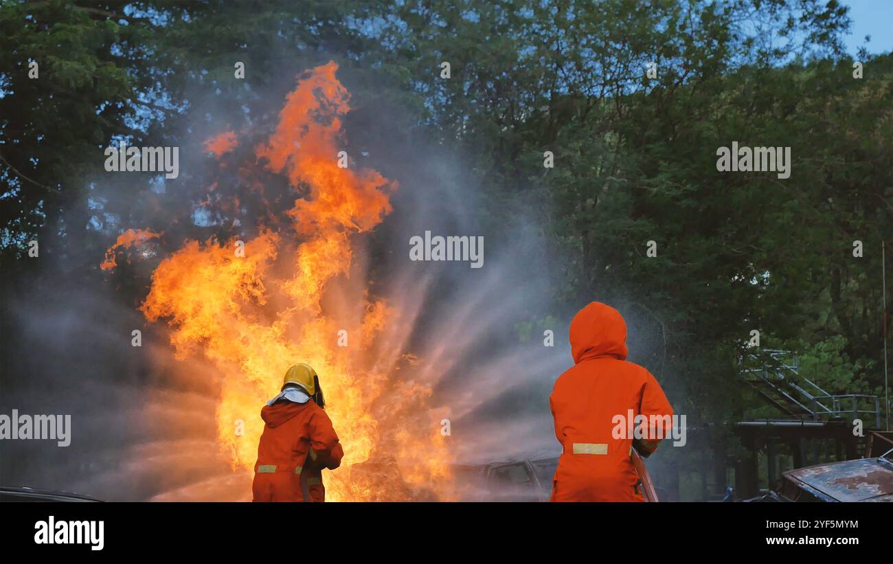 Firefighter fighting with flame using fire hose chemical water foam ...