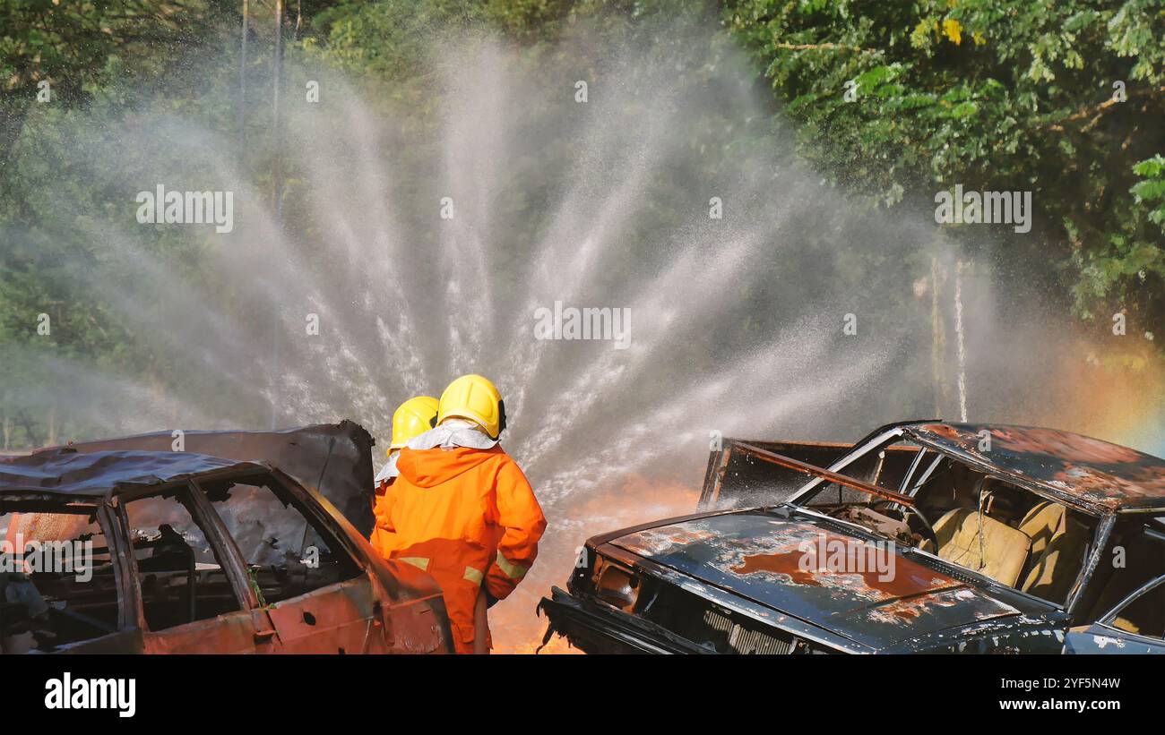 Firefighter fighting with flame using fire hose chemical water foam ...