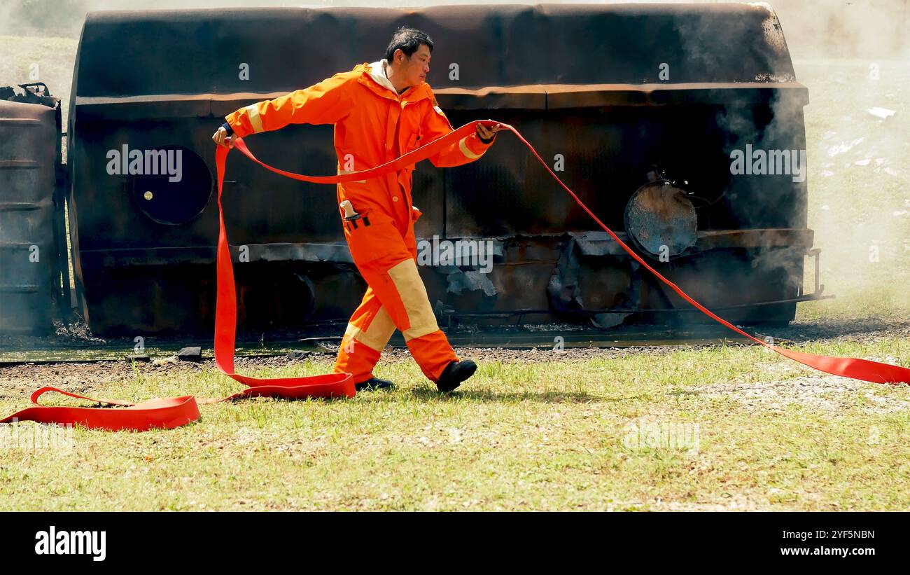 Firefighter fighting with flame using fire hose chemical water foam ...