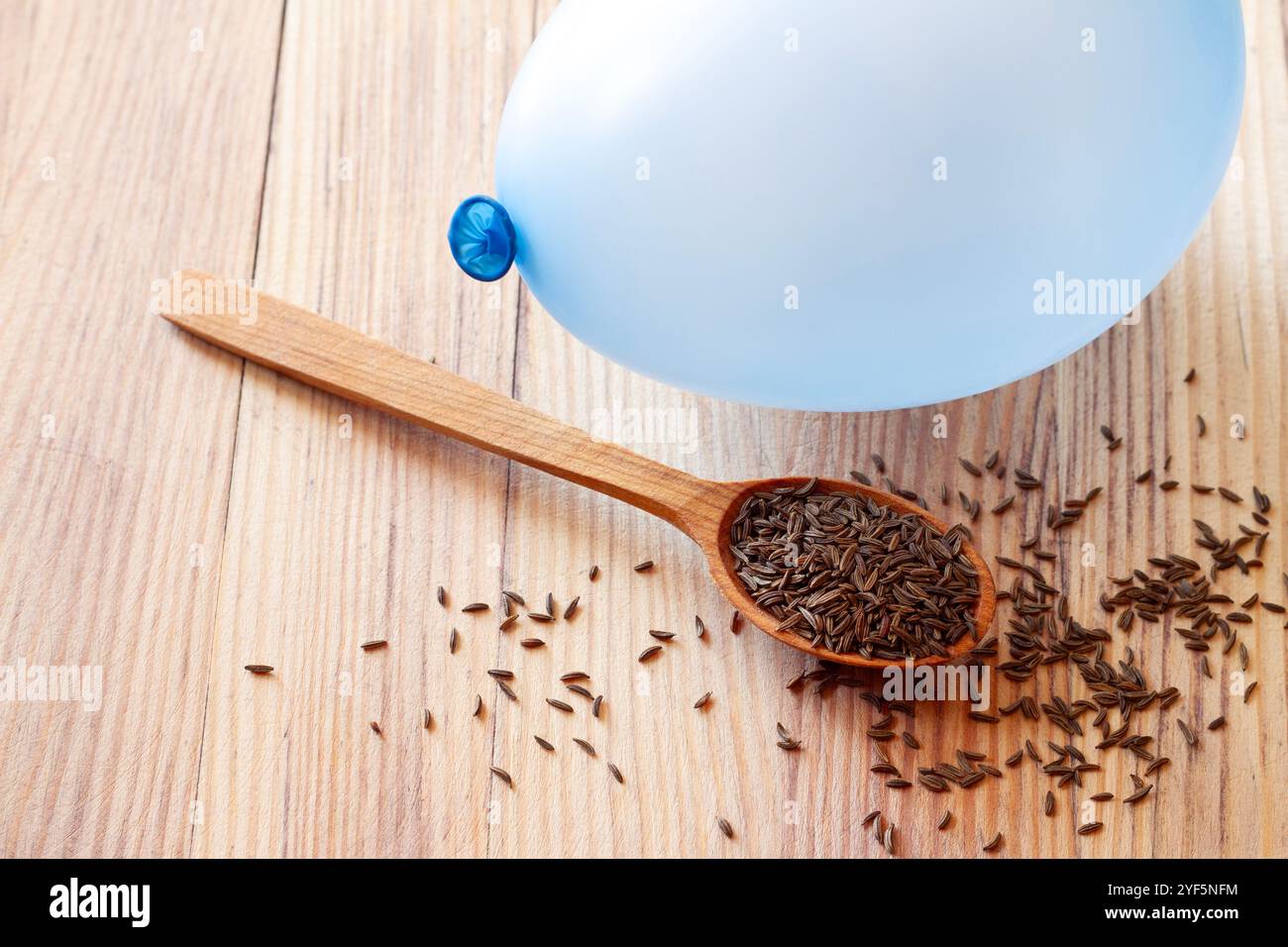 Caraway seeds on spoon with inflated balloon, natural remedy for ...