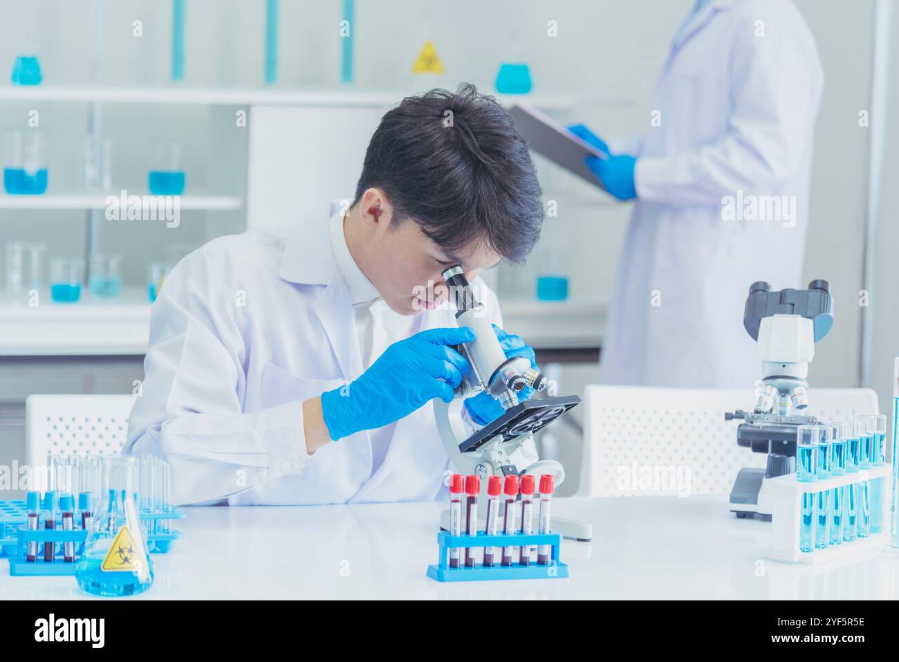 Male Scientist look into Microscope research in science laboratory ...