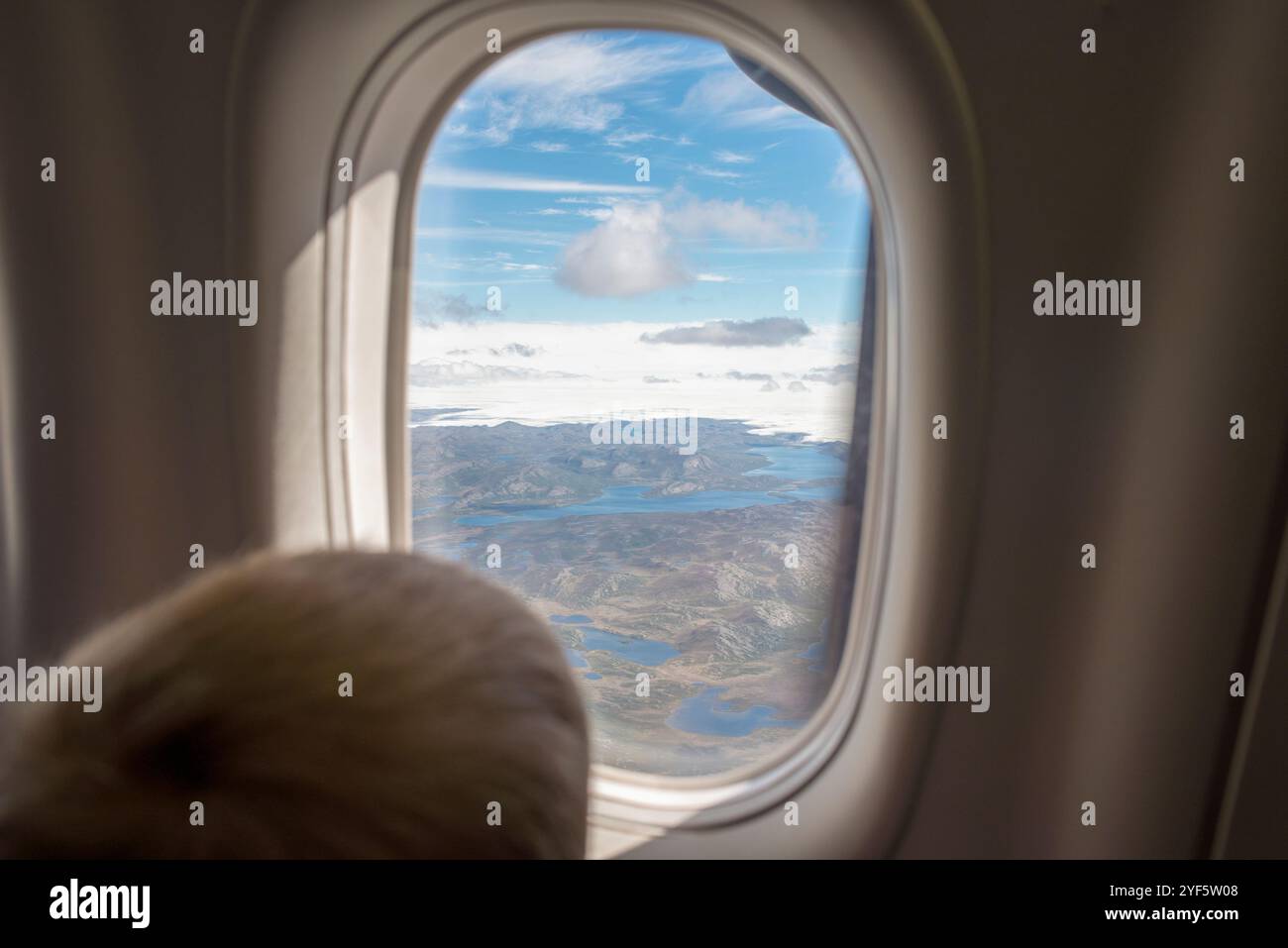 a child gazing out of an airplane window, mesmerized by the ...