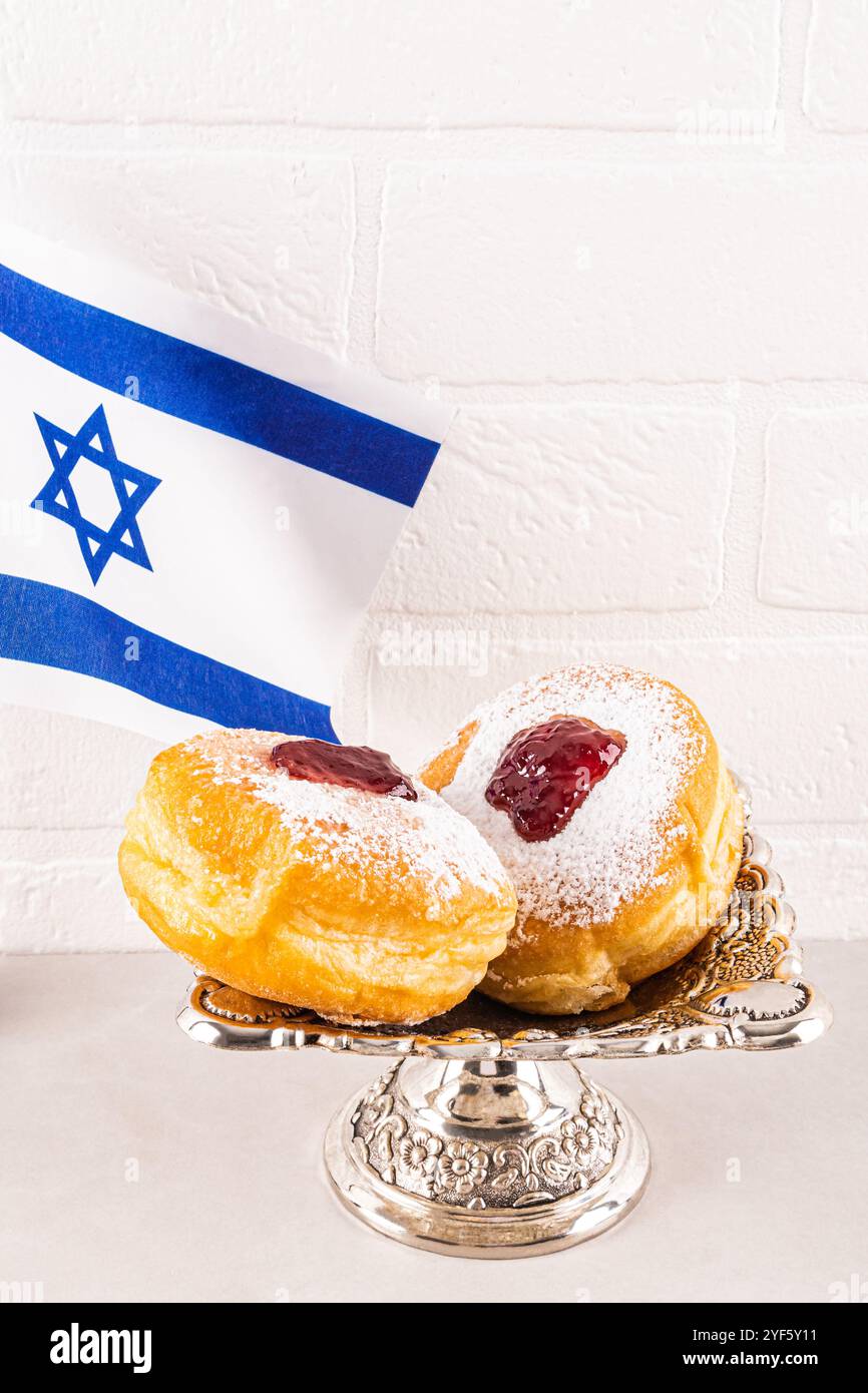 A silver vase with traditional donuts for Hanukkah against the ...