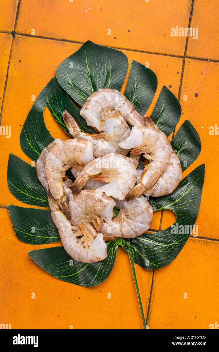 Uncooked Raw white shrimps prawns. Top view. Orange background Stock ...