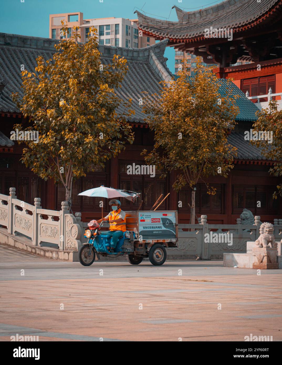A sanitation worker on a three-wheeled utility vehicle equipped with an ...