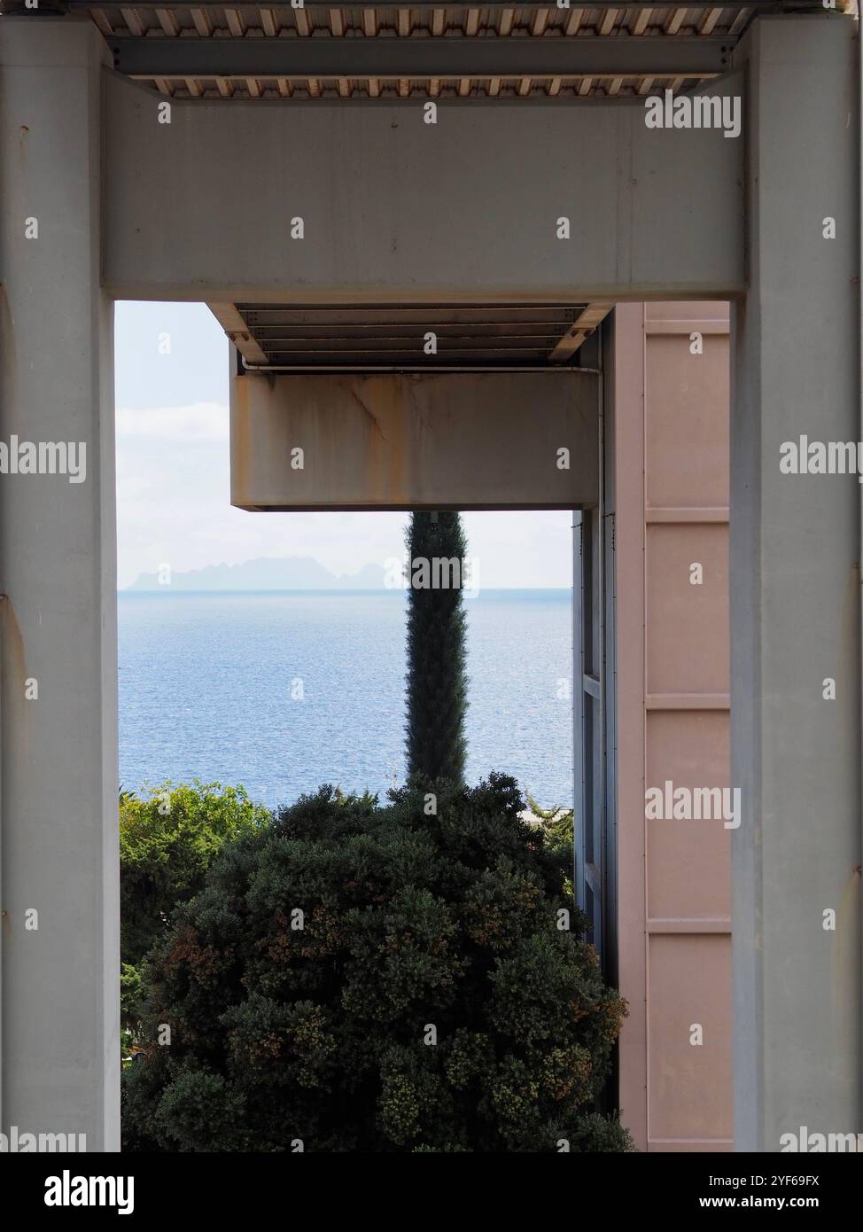 An architectural structure on the coast, framed by lush vegetation and ...
