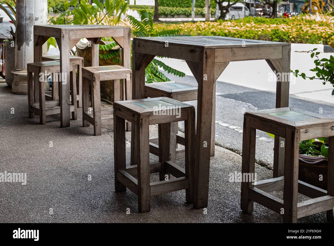 Outdoor cafe with wooden tables, stools on a city street. Wooden tables ...