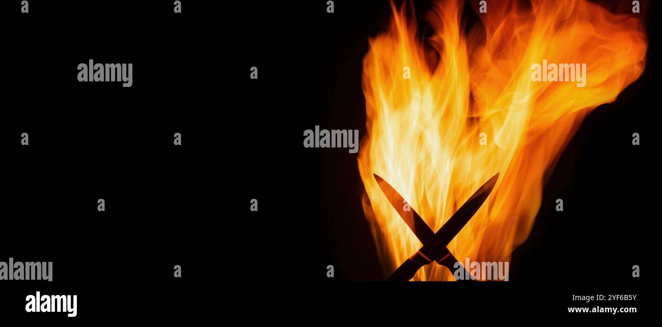 Two crossed knives in tongues of hot flame on a black background Stock ...
