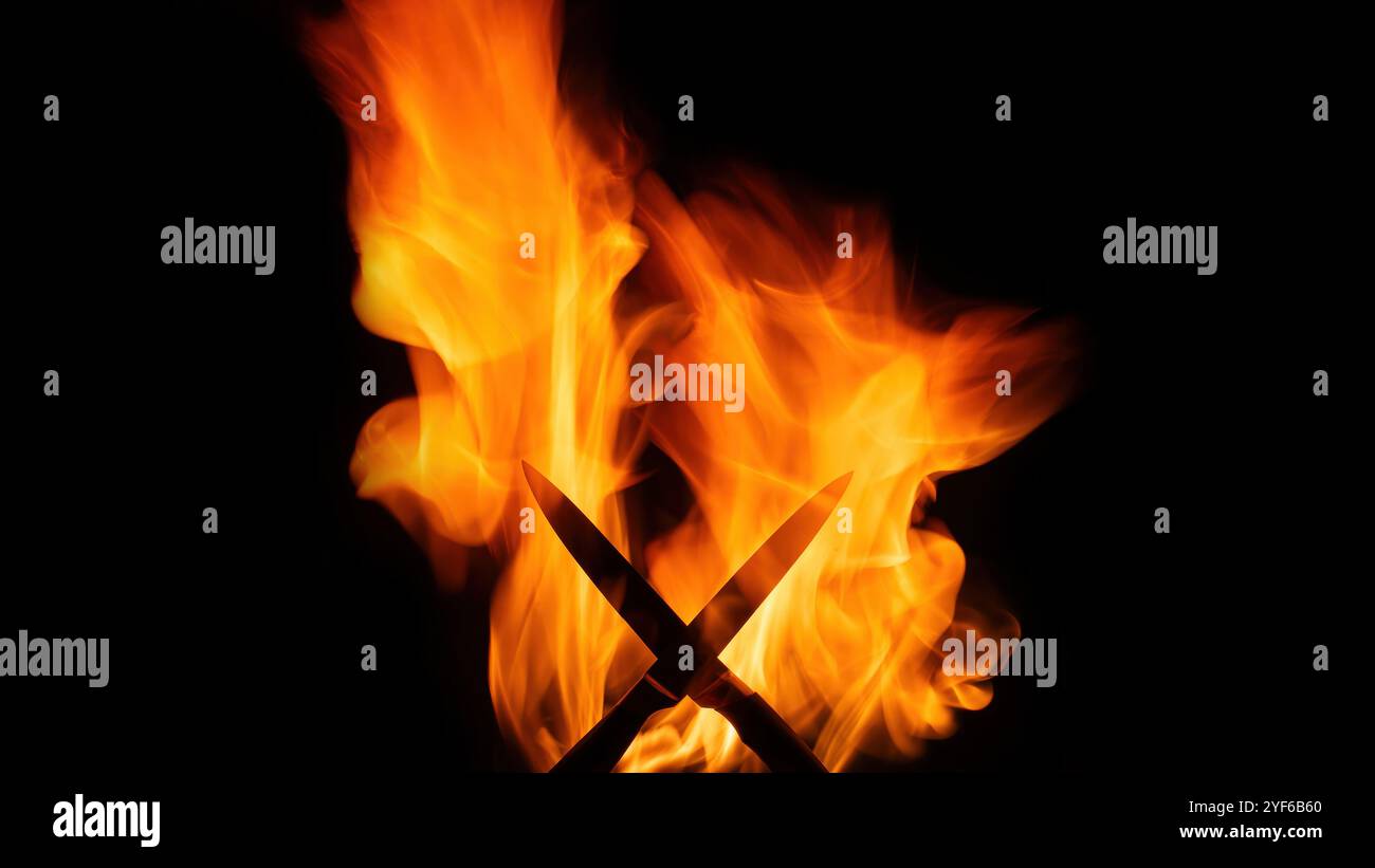 Two crossed knives in tongues of hot flame on a black background Stock ...