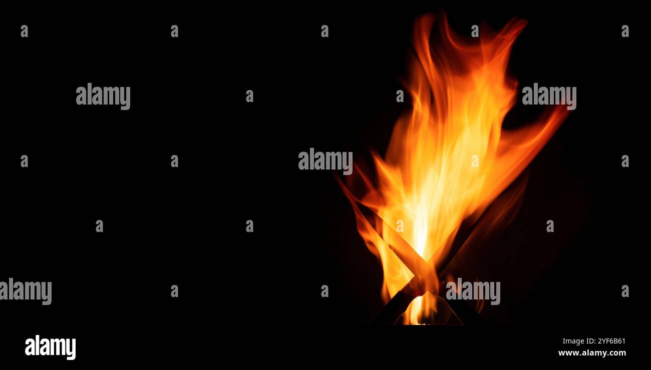 Two crossed knives in tongues of hot flame on a black background Stock ...