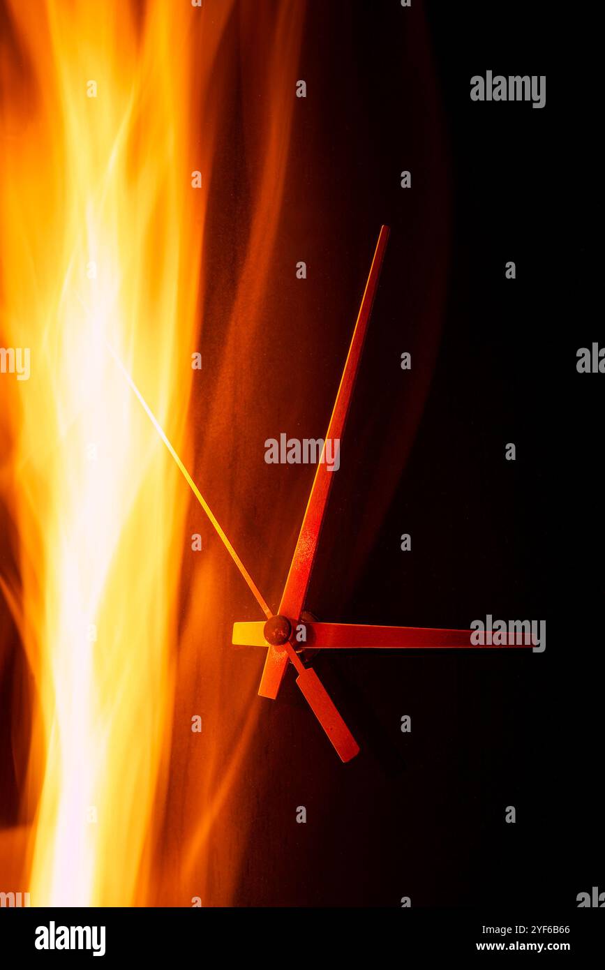 Clock hands in tongues of hot flame on a black background Stock Photo ...