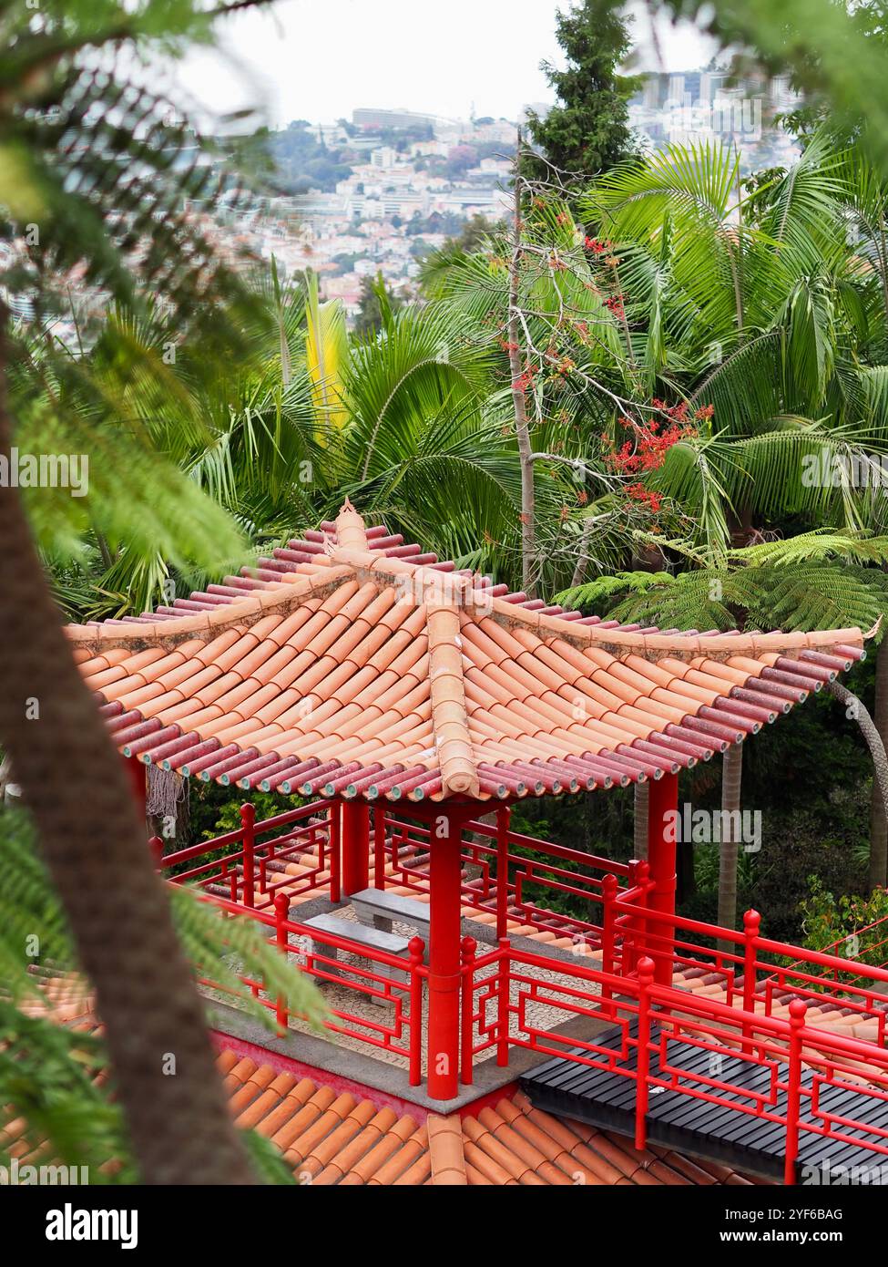 A beautiful traditional red pagoda situated amidst lush tropical ...