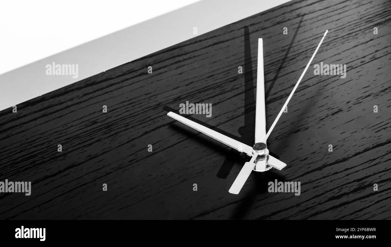 Clock arrows on a black background. Black and white Stock Photo - Alamy