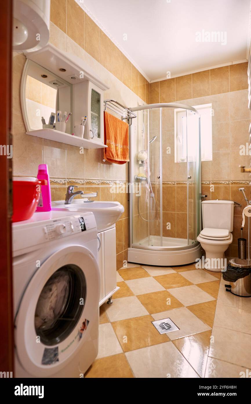 Small bathroom with shower, toilet, washbasin, washing machine and ...