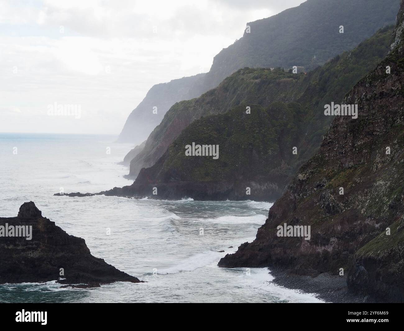 The scene captures distant misty cliffs merging smoothly with the vast ...