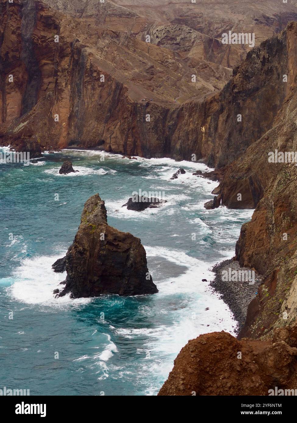 A dramatic coastal scene of rugged cliffs standing against the ocean as ...