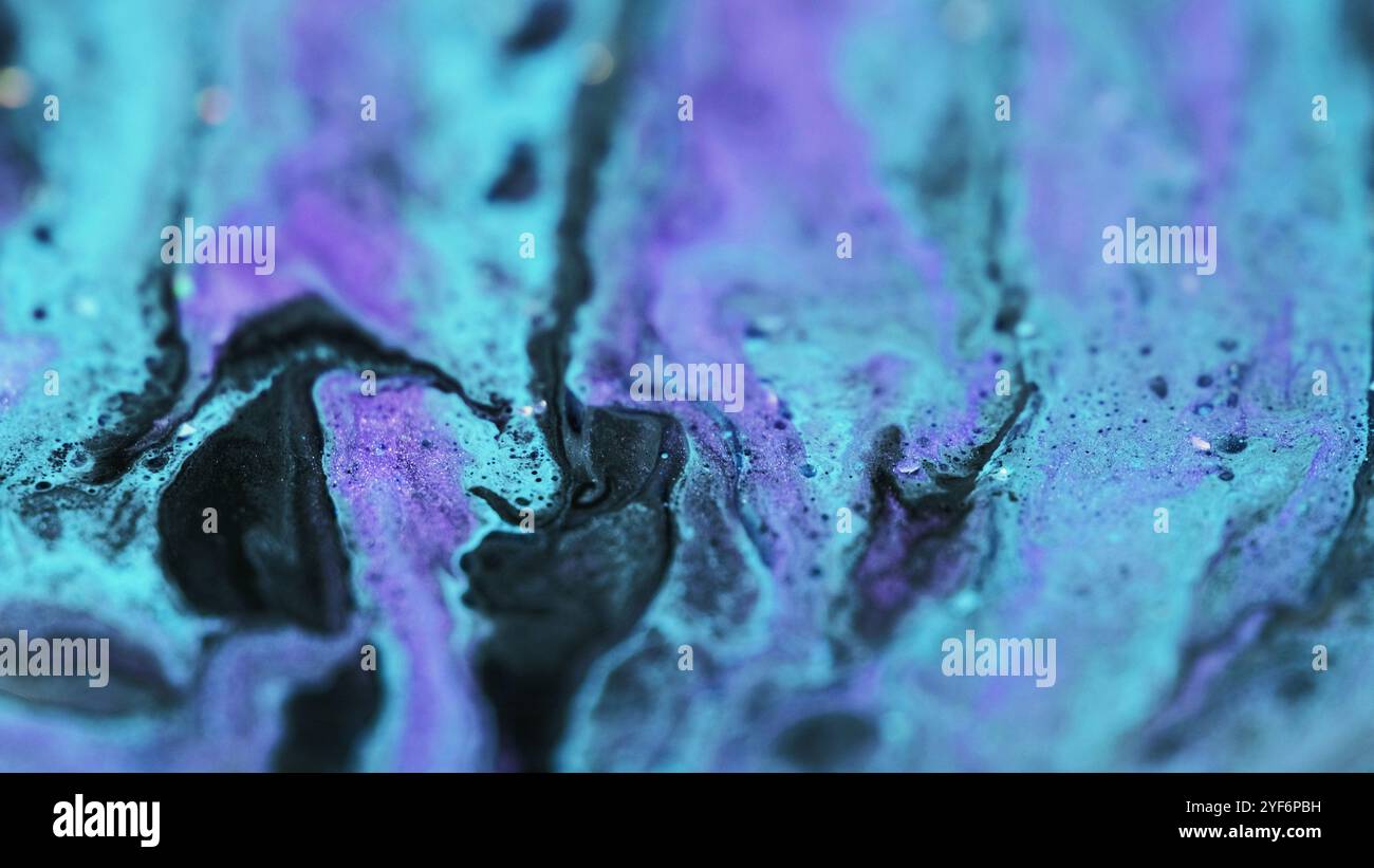 Fluid art. Glitter paint spill. Defocused blue purple black color ...