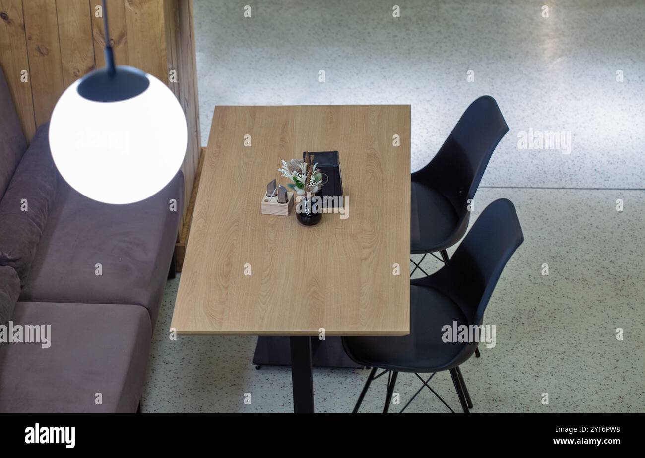 An empty table in a cafe with a sofa and two chairs awaits visitors ...