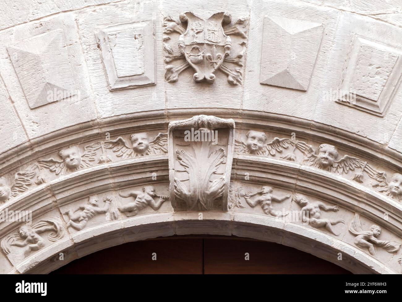 The intricate carved arch displays angels and a coat of arms ...