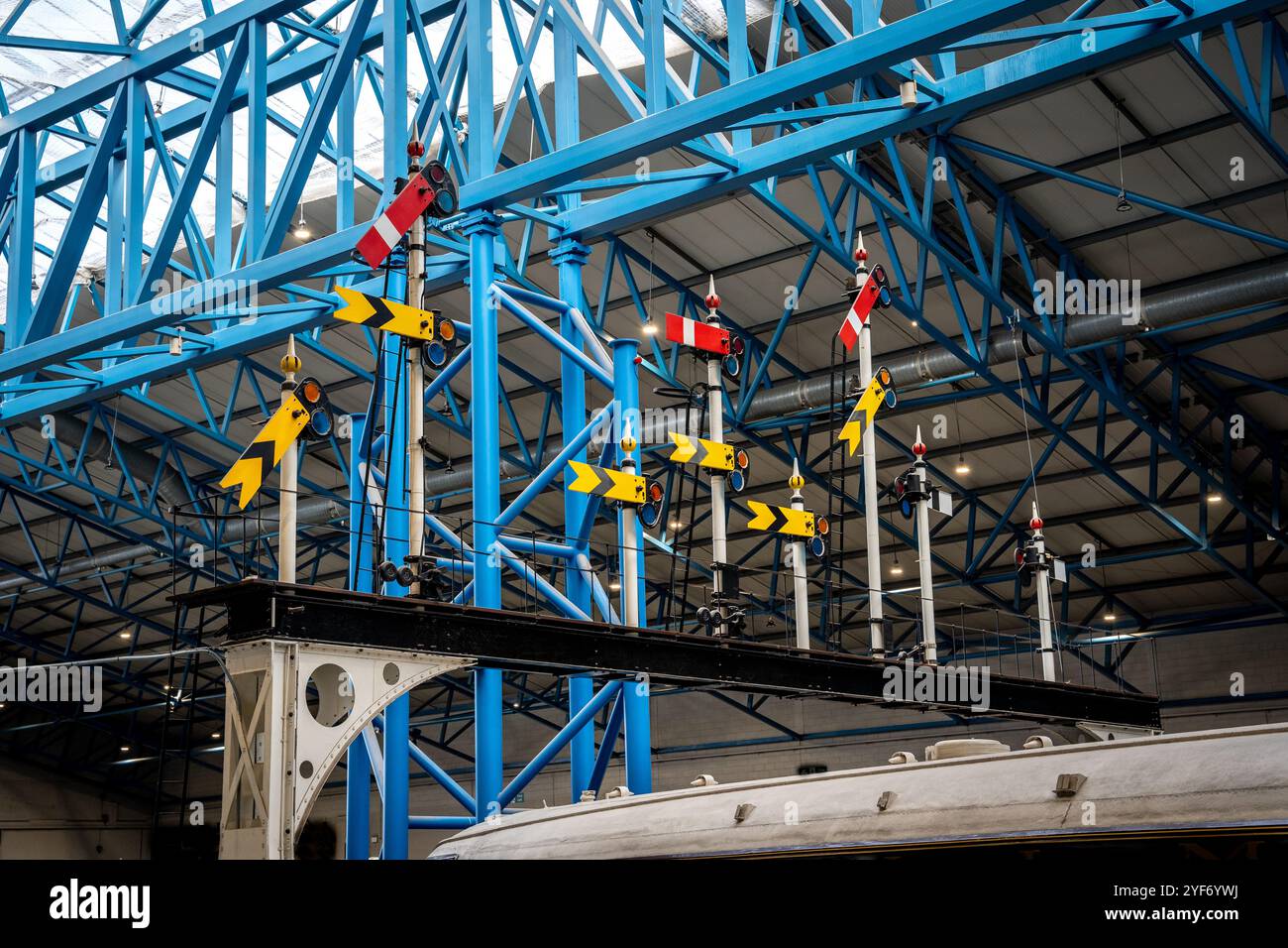 A group of historic semaphore rail signals on a gantry in the UK with ...