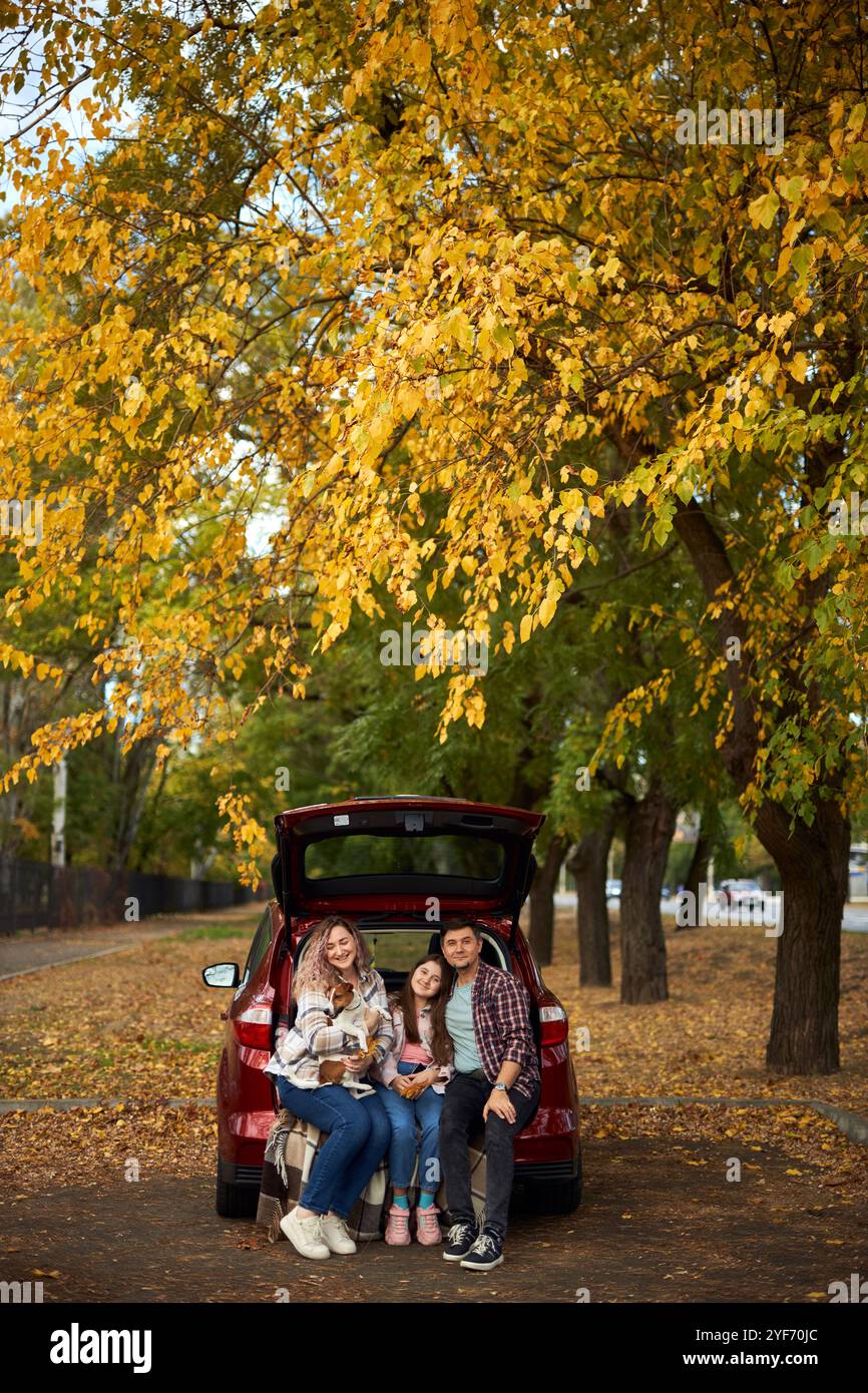 Family with dog siting together in car trunk Stock Photo - Alamy