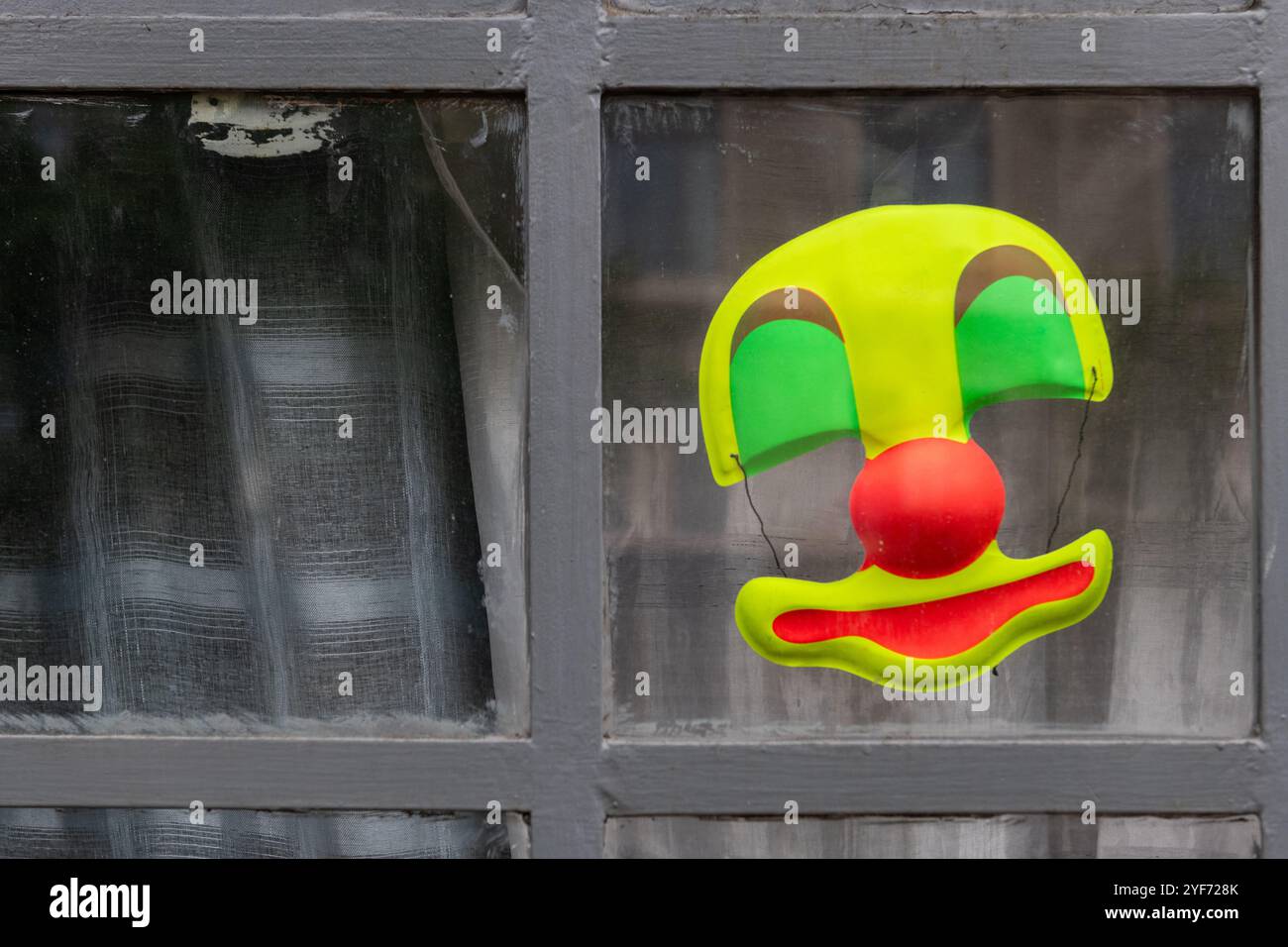 Holiday costume face masks taped to windows of a storefront in ...