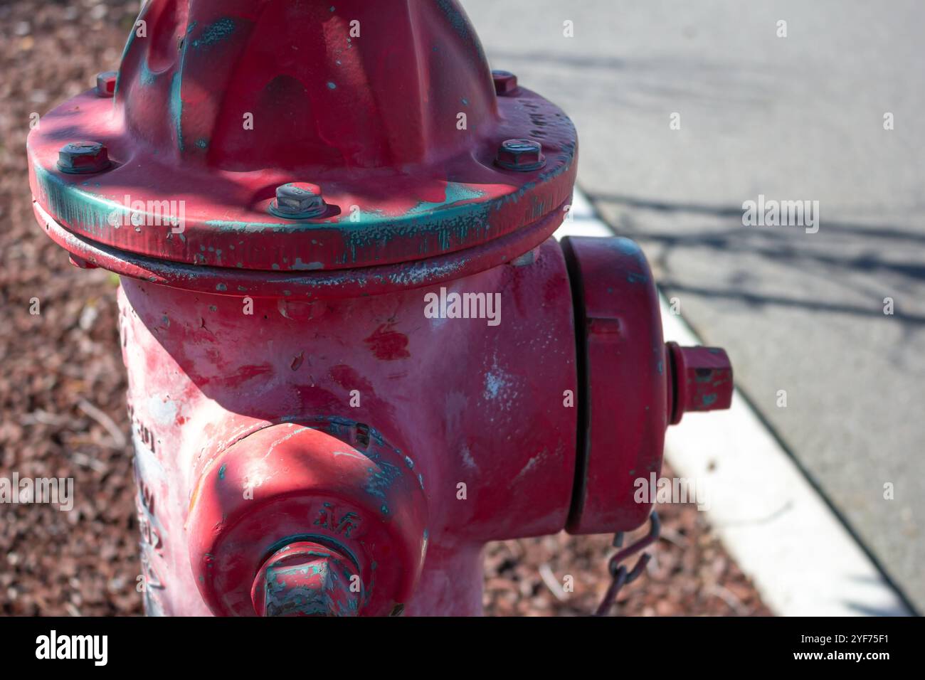 A view of a red fire hydrant on the side of the road in a parking lot ...