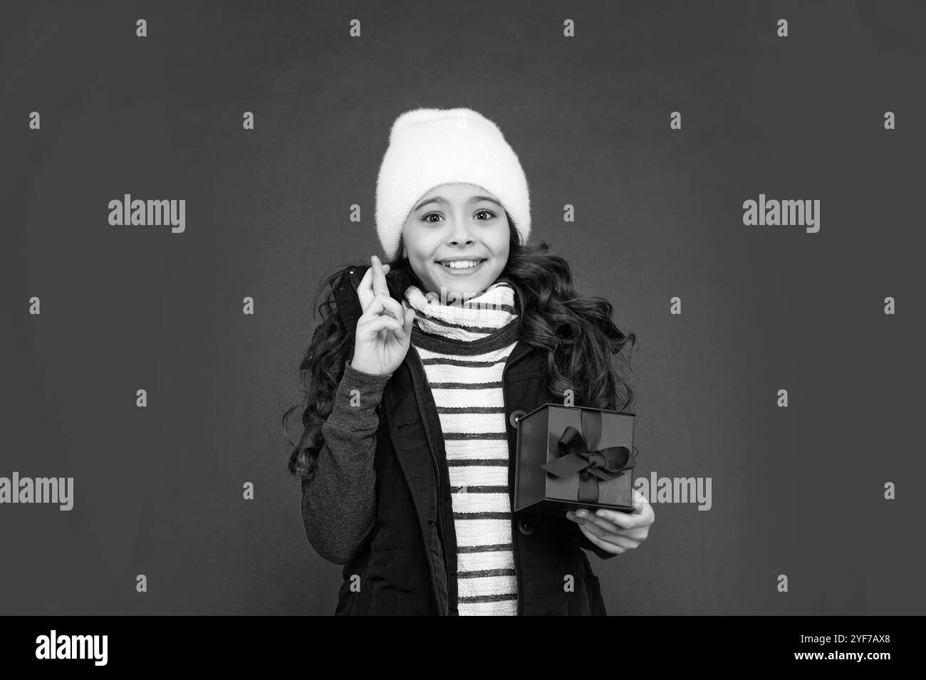 happy child in puffer jacket and hat hold box. kid with present. teen ...