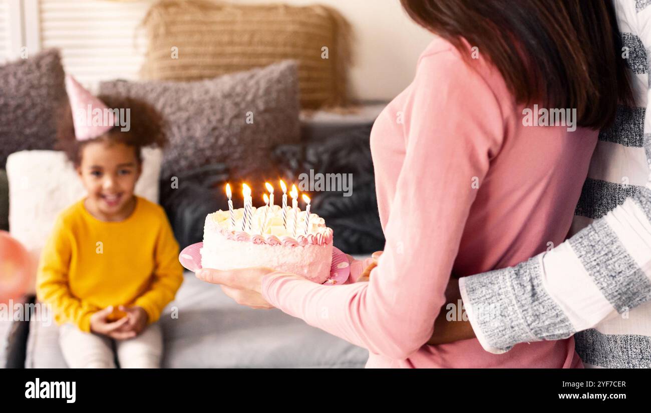 Birthday of little girl. Parents give cake Stock Photo - Alamy