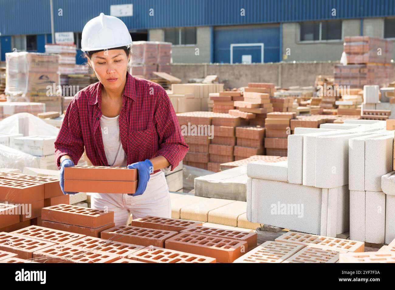 Woman carrying clay bricks in outdoor storage Stock Photo - Alamy
