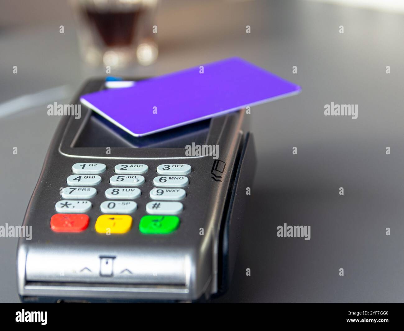 Purple credit card positioned on payment device for tap to pay Stock ...