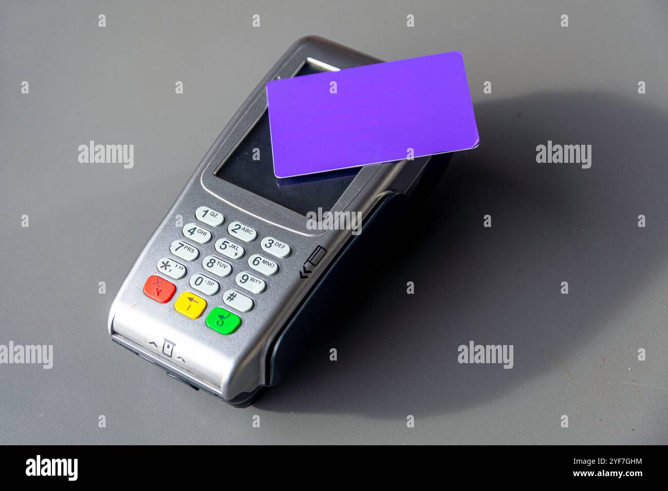Contactless payment terminal with purple credit card Stock Photo - Alamy